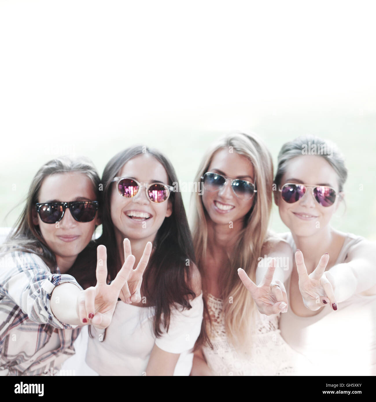 Happy smiling girlfriends showing a v hand sign Stock Photo - Alamy