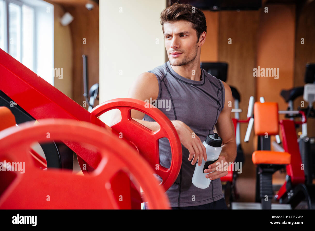 Portrait of a handsome young bodybuilder resting after workout at ...
