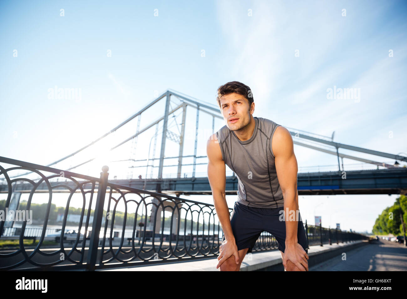 Concentrated young handsome sports man resting after running while ...