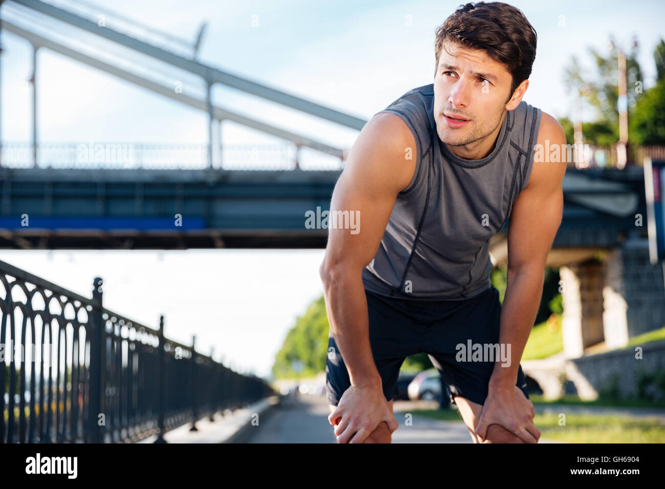 Concentrated young handsome sports man resting after running while ...
