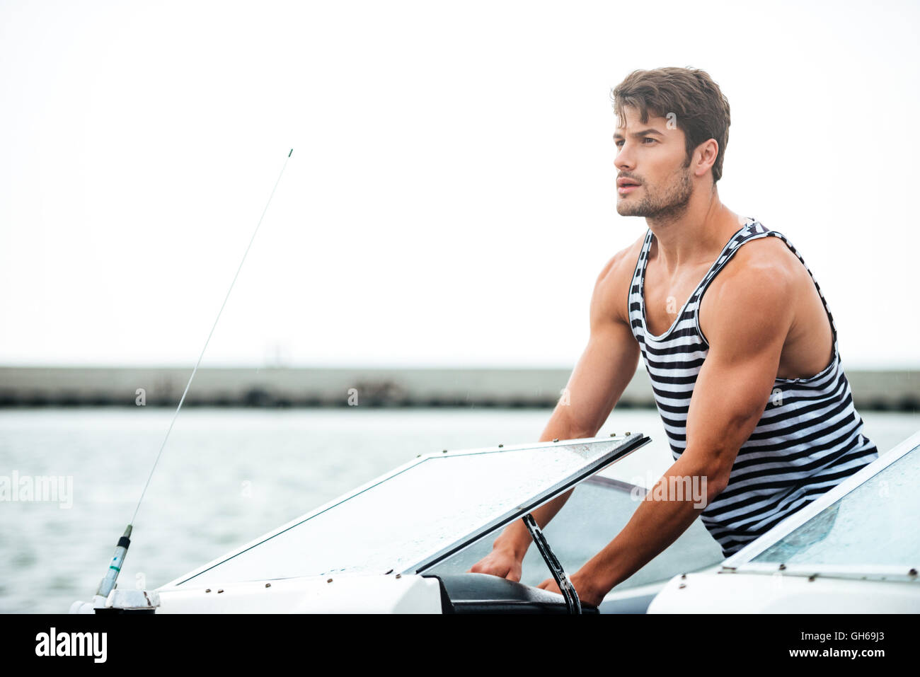 Young handsome bearded sailor man driving his motor boat Stock Photo ...