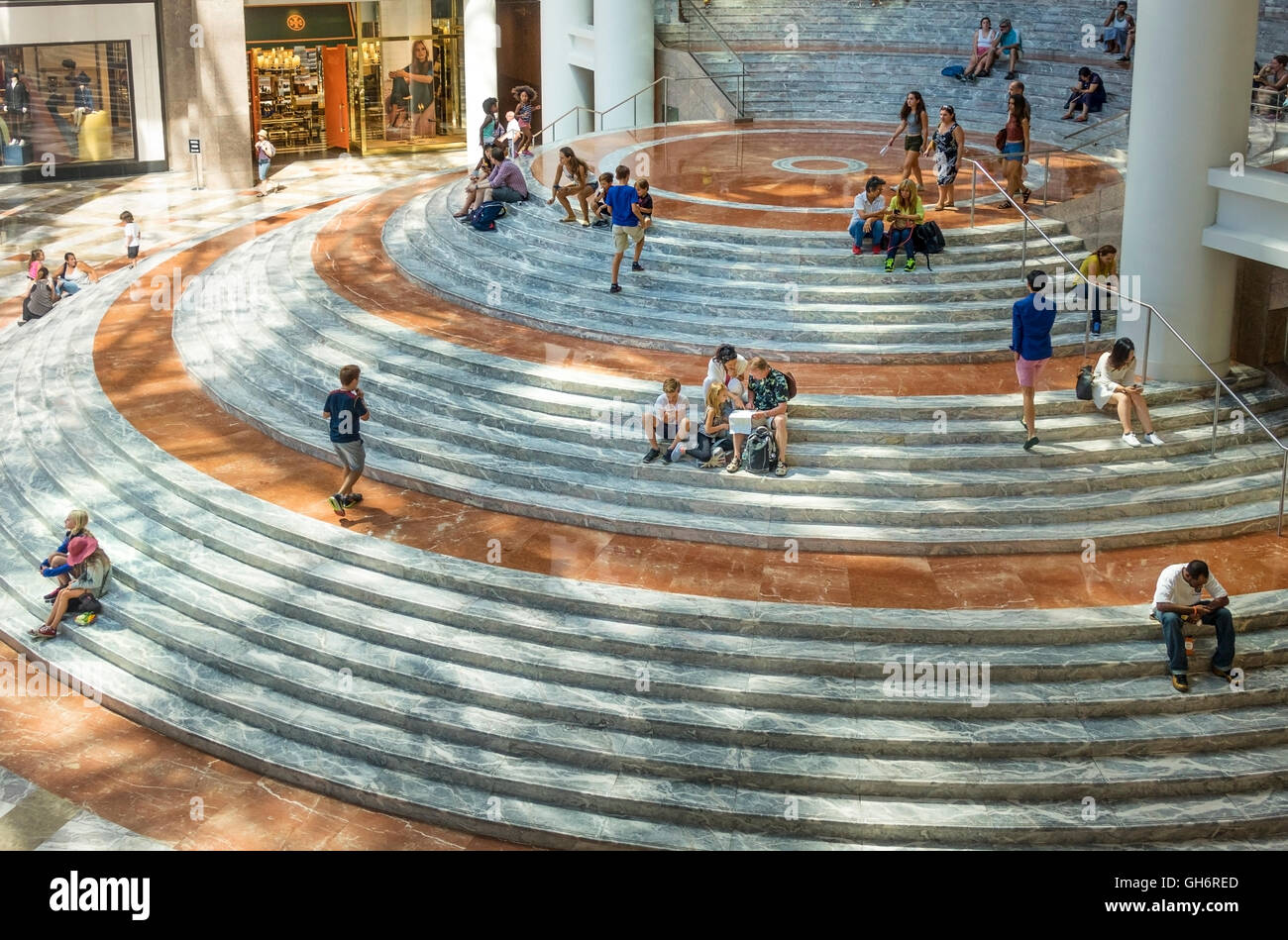 Visitors sitting on the curved marble steps in the Winter Garden Atrium ...