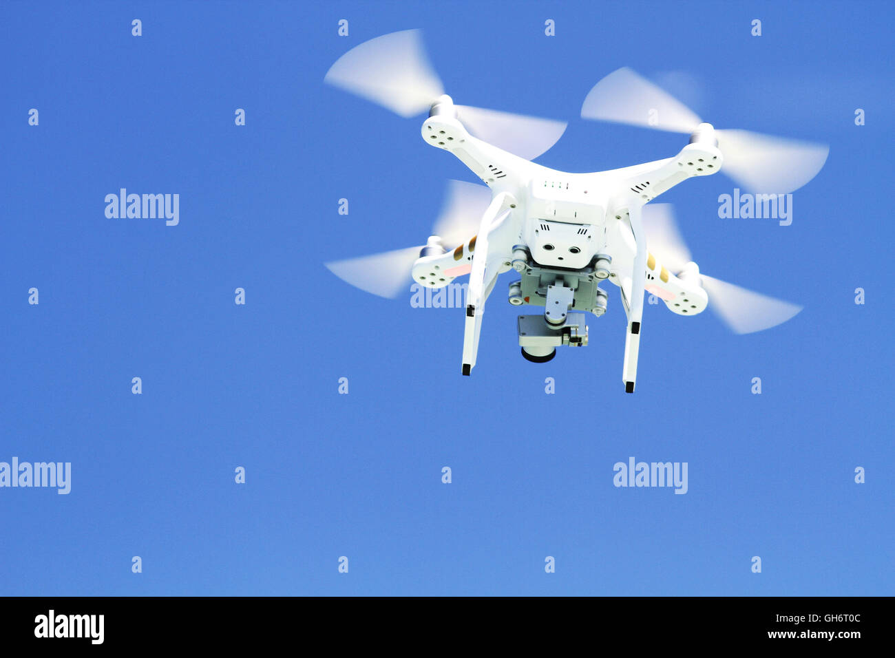 White drone flying with camera record liens against blue sky Stock ...