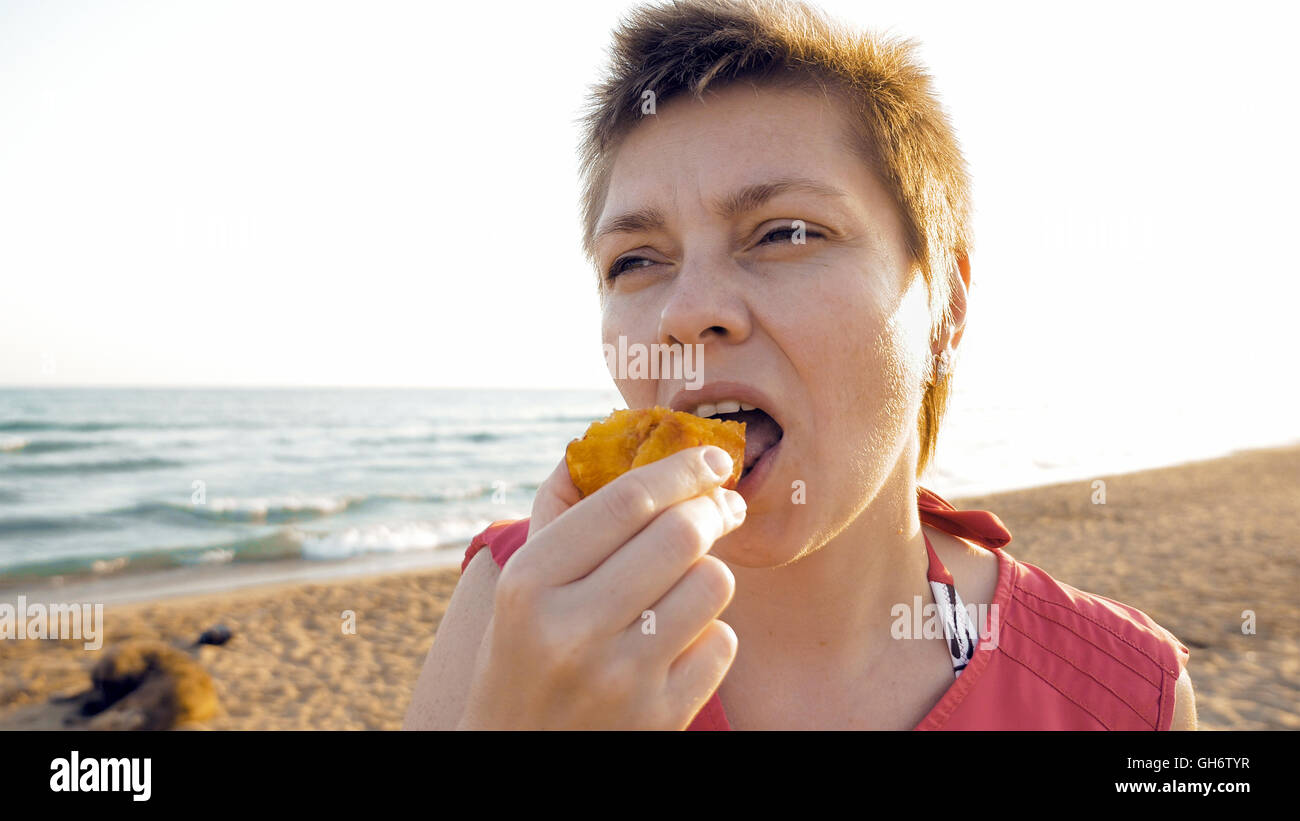 Woman eating food beach hi-res stock photography and images - Alamy