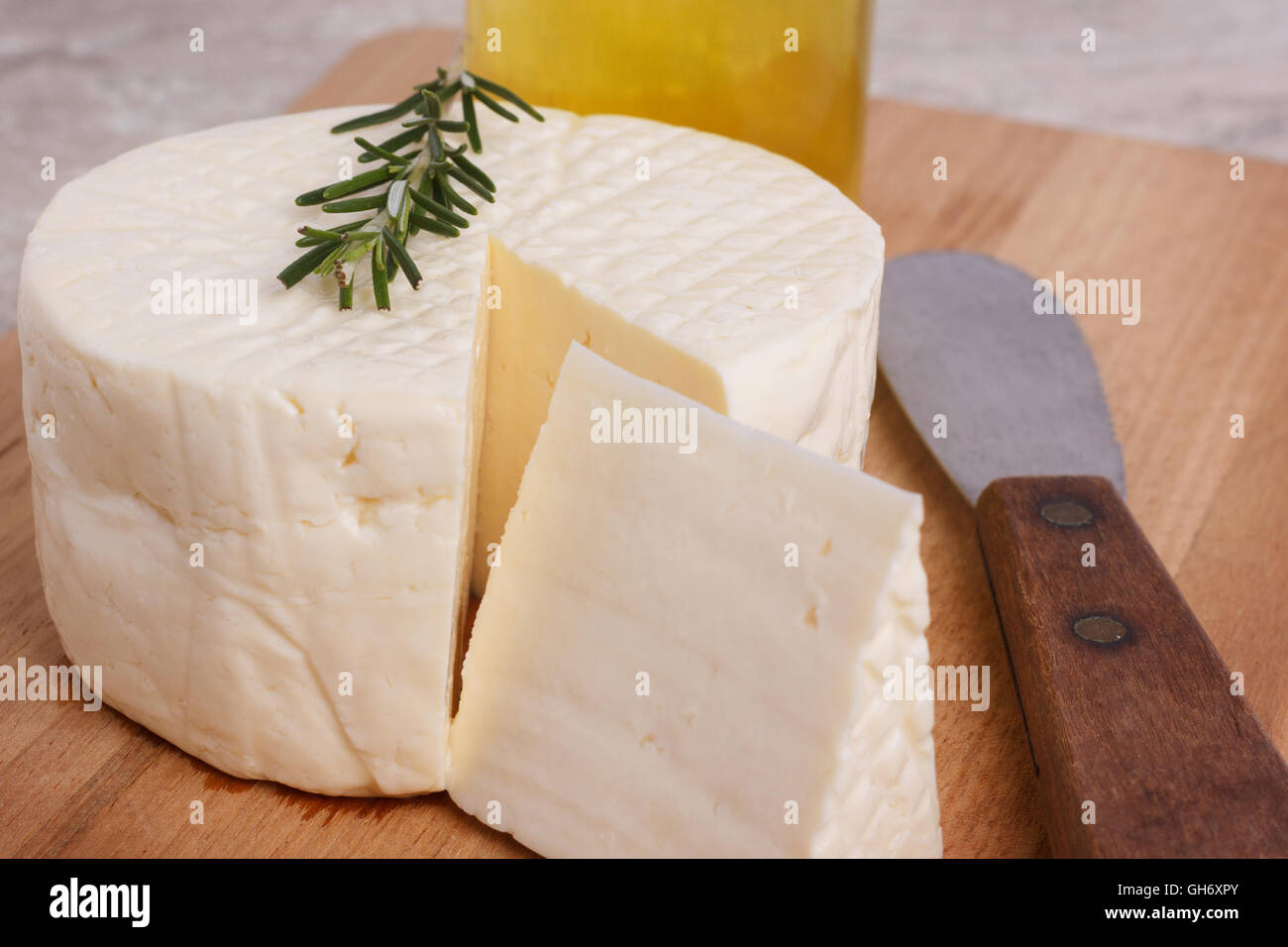 Wheel of brazilian traditional cheese Minas on wooden board with olive ...