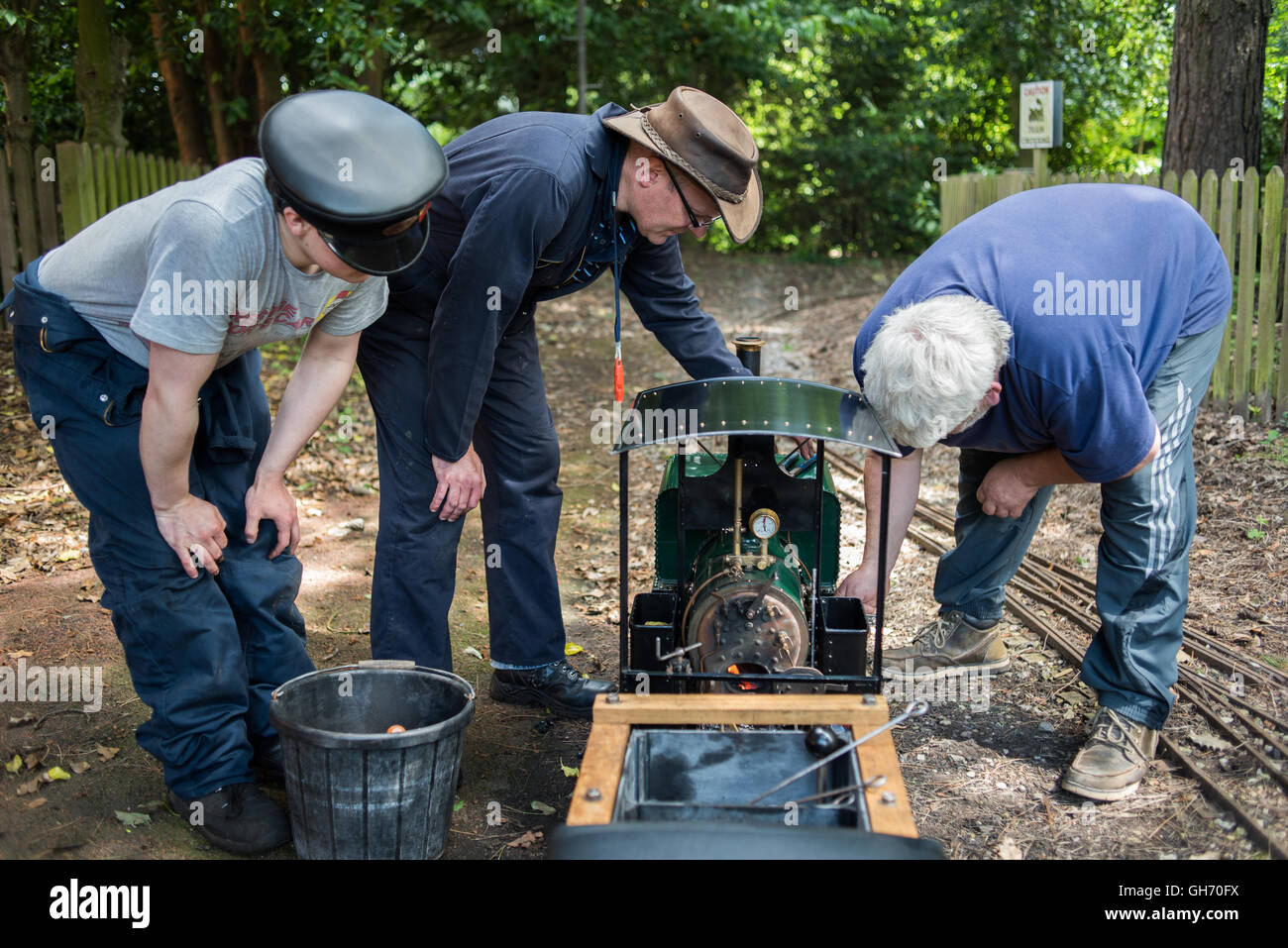 men priming a miniature steam locomotive for journey at papplewick ...