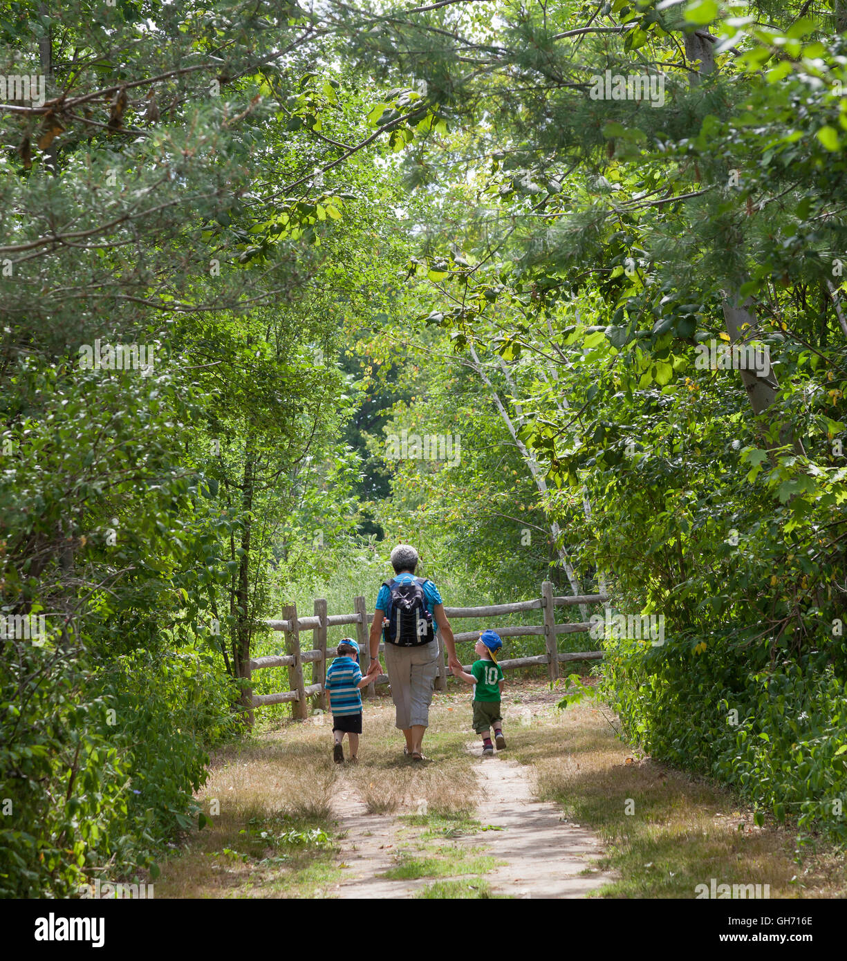 Mother and two small children going for a hike on a field trip and day ...