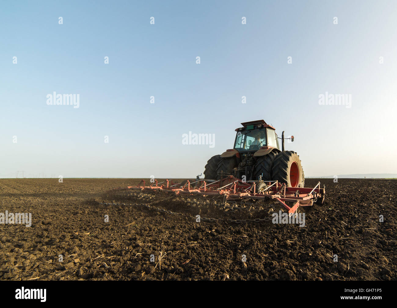 Tractor preparing land for sowing Stock Photo - Alamy