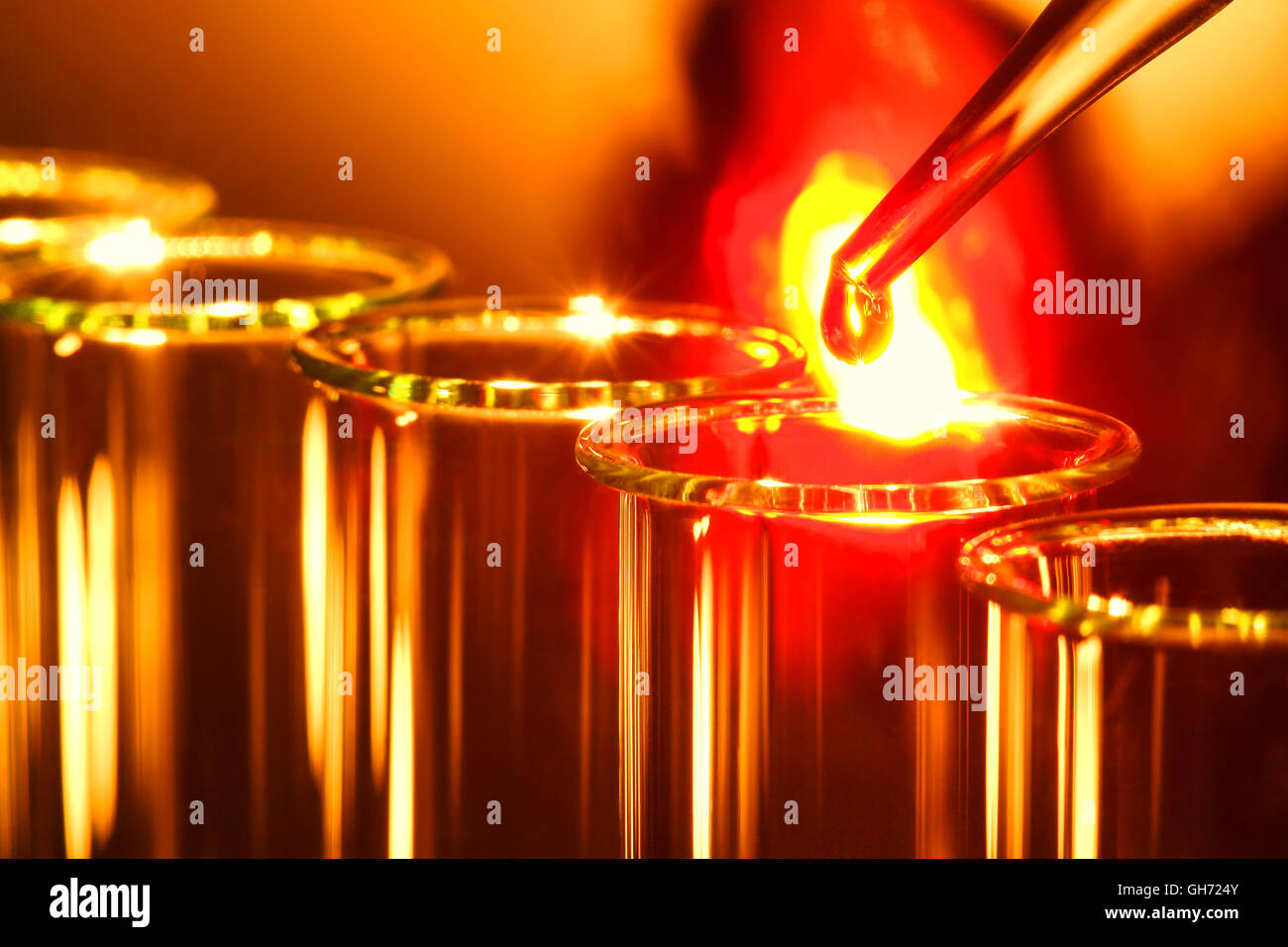 Laboratory pipette with drop of burning hot melting liquid with intense ...