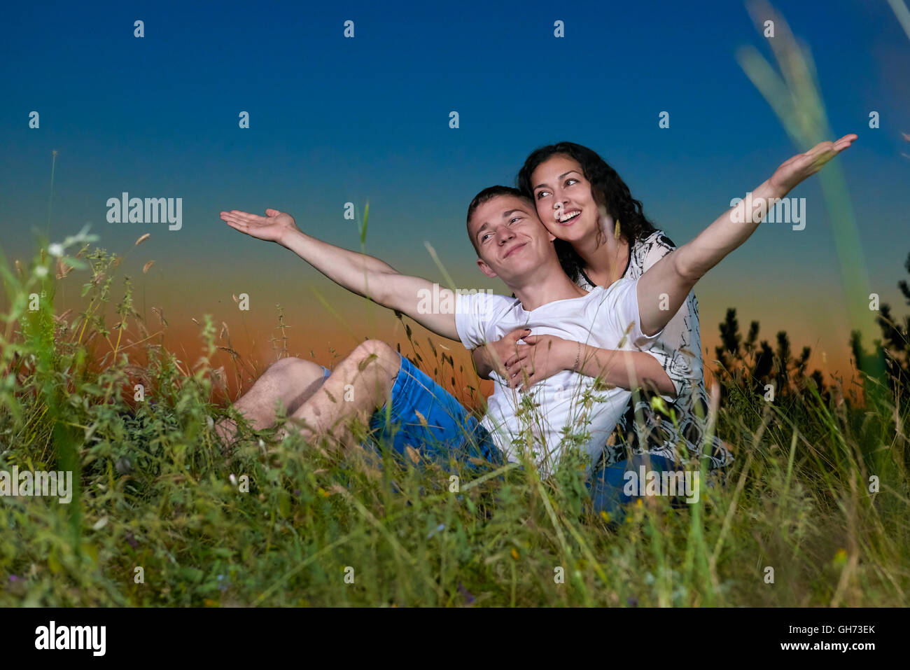 young romantic couple open arms and having fun at sunset on outdoor ...