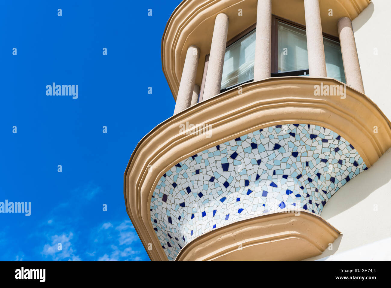 Detail of building window with brown columns and white and blue tiles ...
