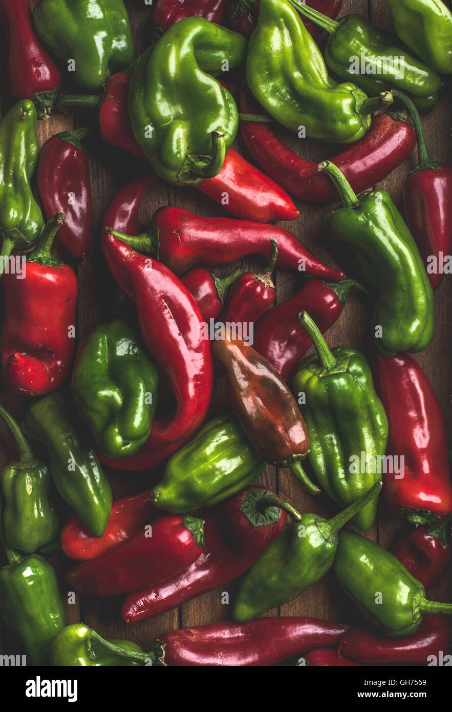 Background of colorful red and green bell peppers over wooden backdrop ...
