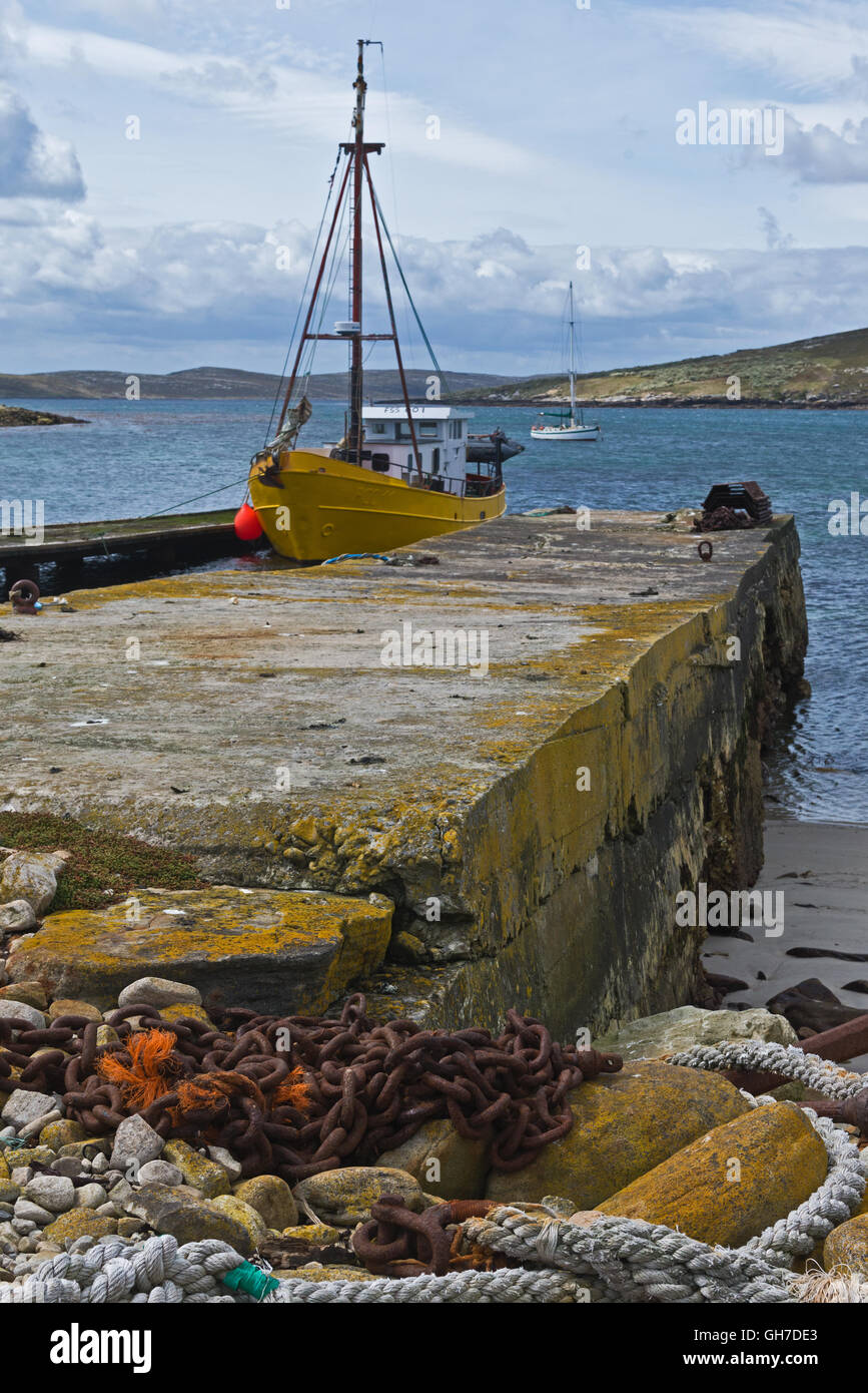 A boat tied up alongside the pier at the settlement on West Point ...