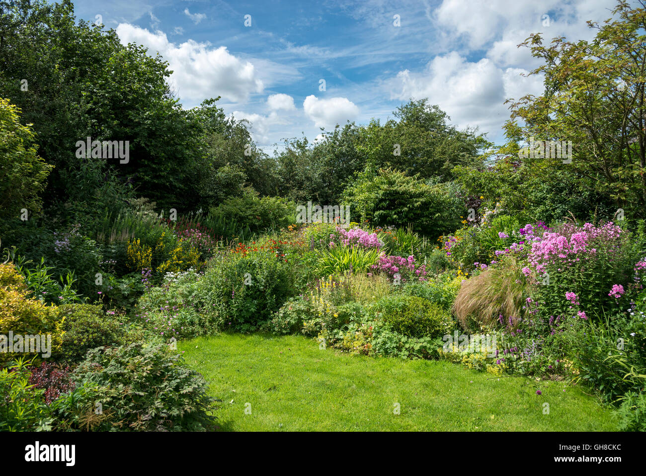 An English cottage garden in August with variety of informal planting ...