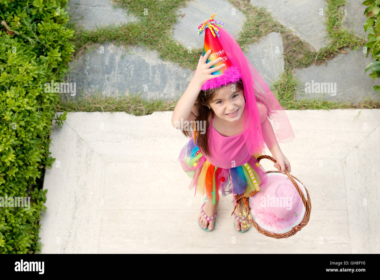 Little girl with pink fancy dress looking up Stock Photo - Alamy