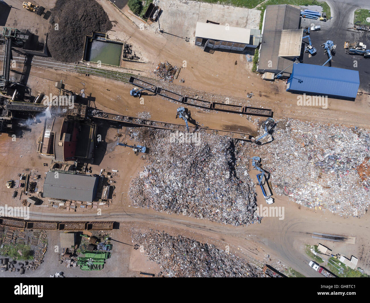 Iron raw materials recycling pile, work machines. Metal waste junkyard ...