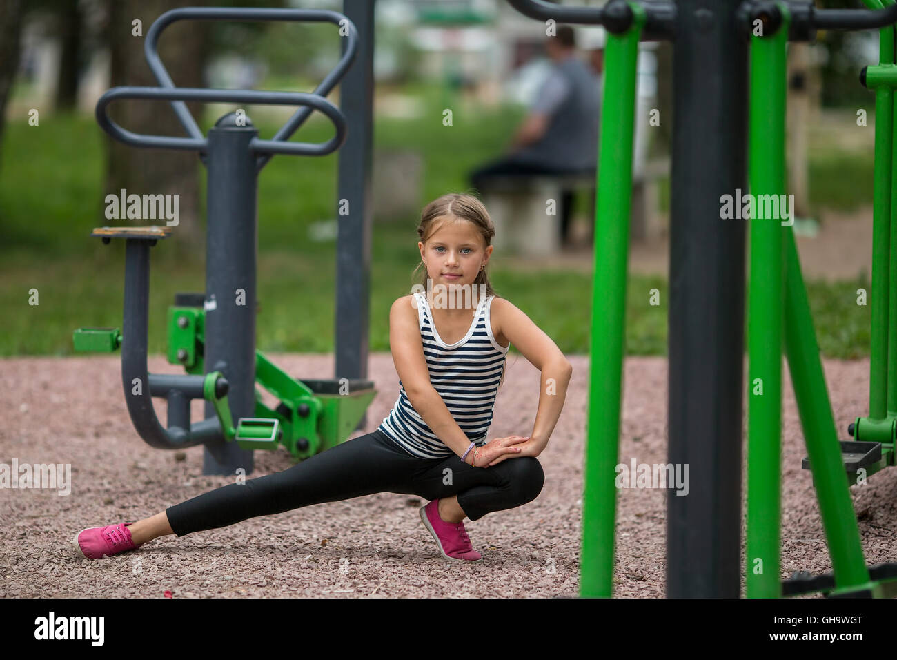 Little sporty girl doing workout on the Playground Stock Photo - Alamy
