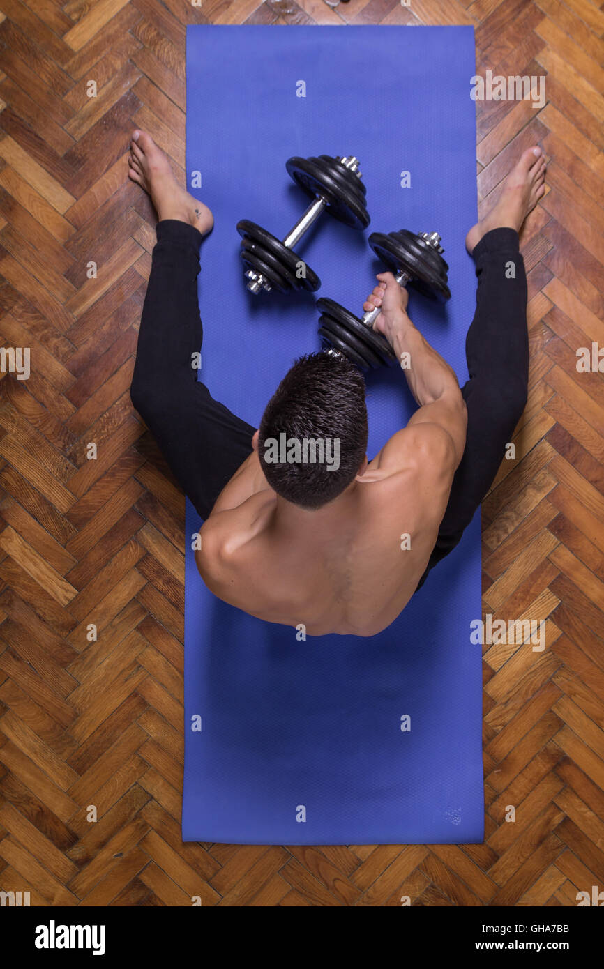 Young man elevated view taking grabbing weights strong back muscles ...