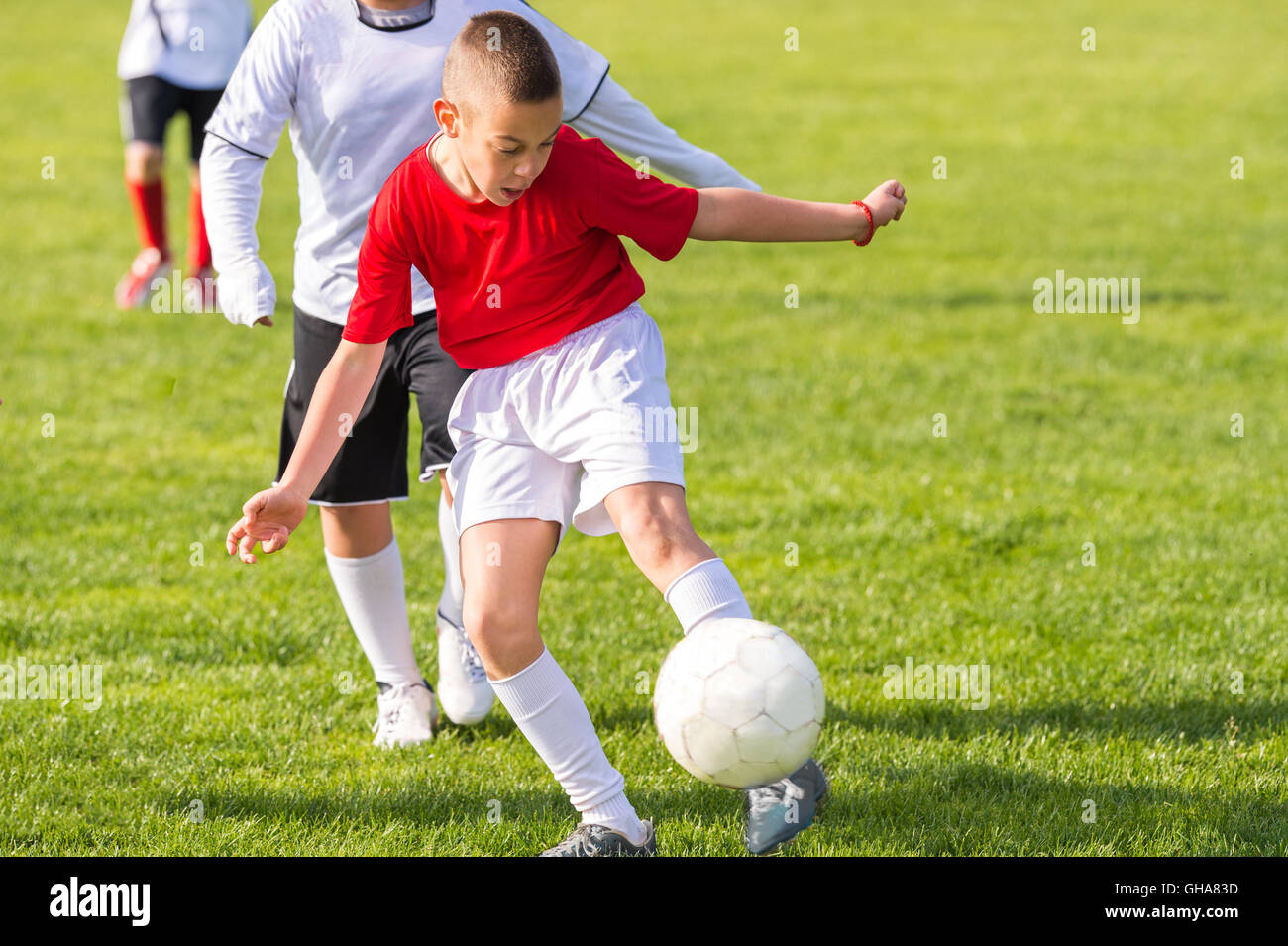boys kicking football on the sports field Stock Photo - Alamy