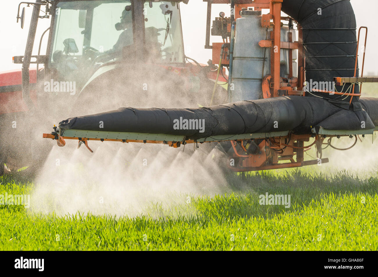 Tractor spraying wheat field with sprayer Stock Photo - Alamy
