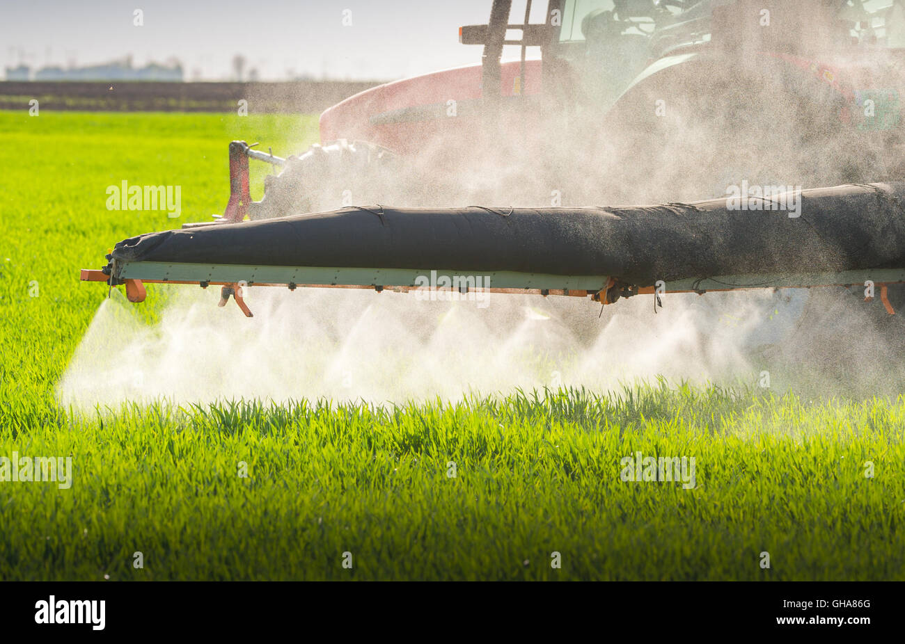 Tractor spraying wheat field with sprayer Stock Photo - Alamy