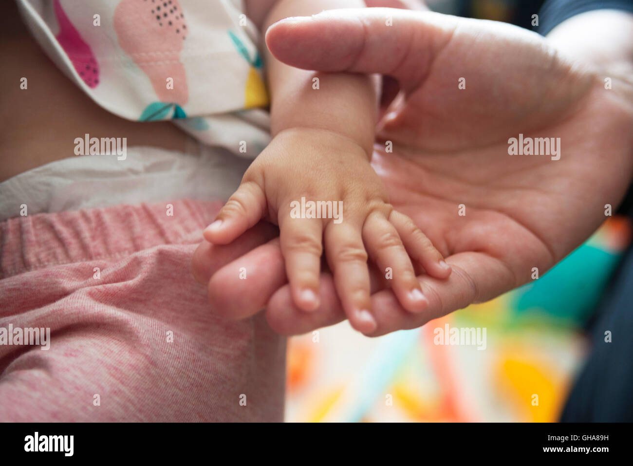 Mother and baby holding hands Stock Photo - Alamy