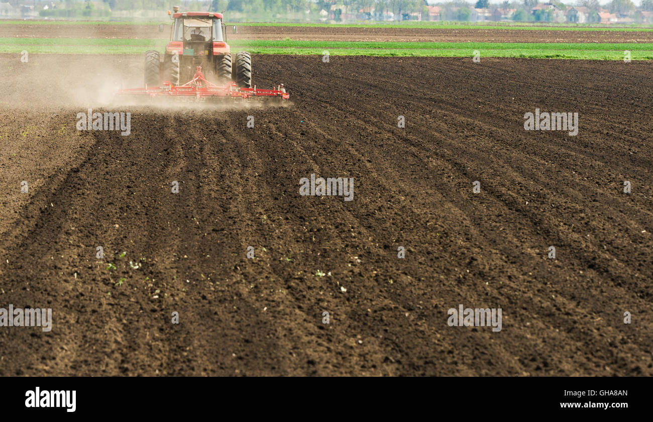 Tractor preparing land for sowing Stock Photo - Alamy