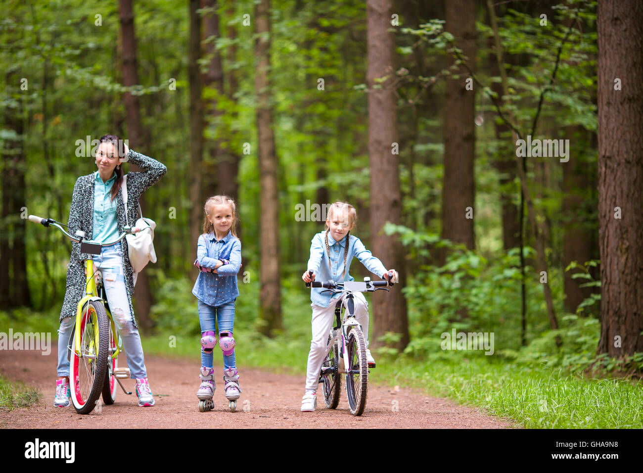 Happy family biking outdoors at the park Stock Photo - Alamy