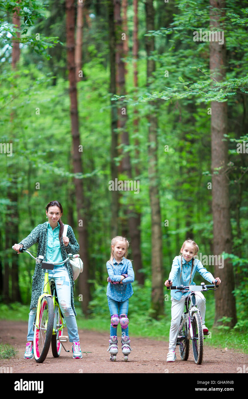 Happy family biking outdoors at the park Stock Photo - Alamy