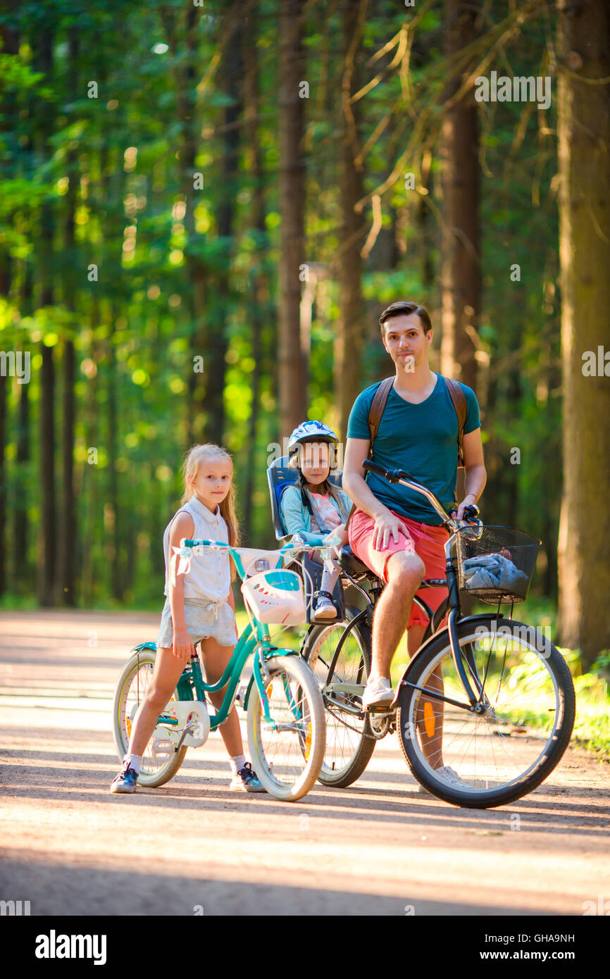 Happy family biking outdoors at the park Stock Photo - Alamy