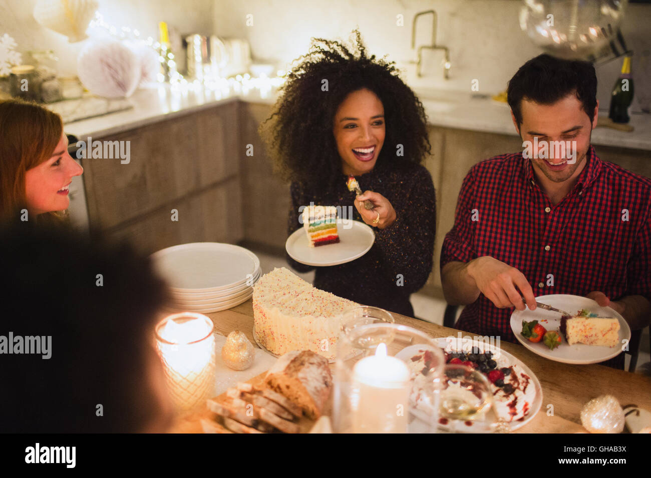 Friends eating cake at candlelight table Stock Photo - Alamy