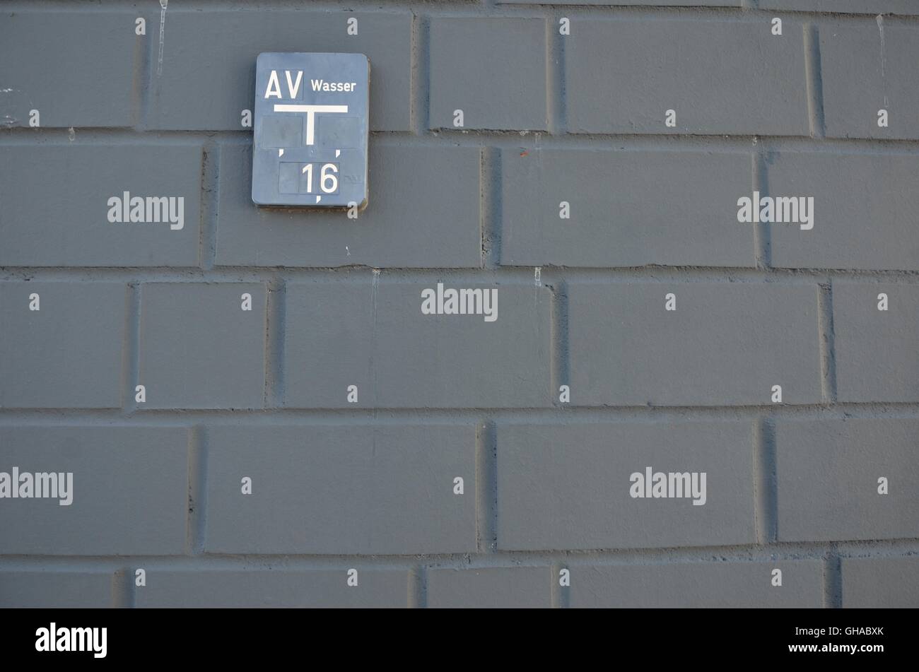 water sign on regular gray brick wall Stock Photo - Alamy