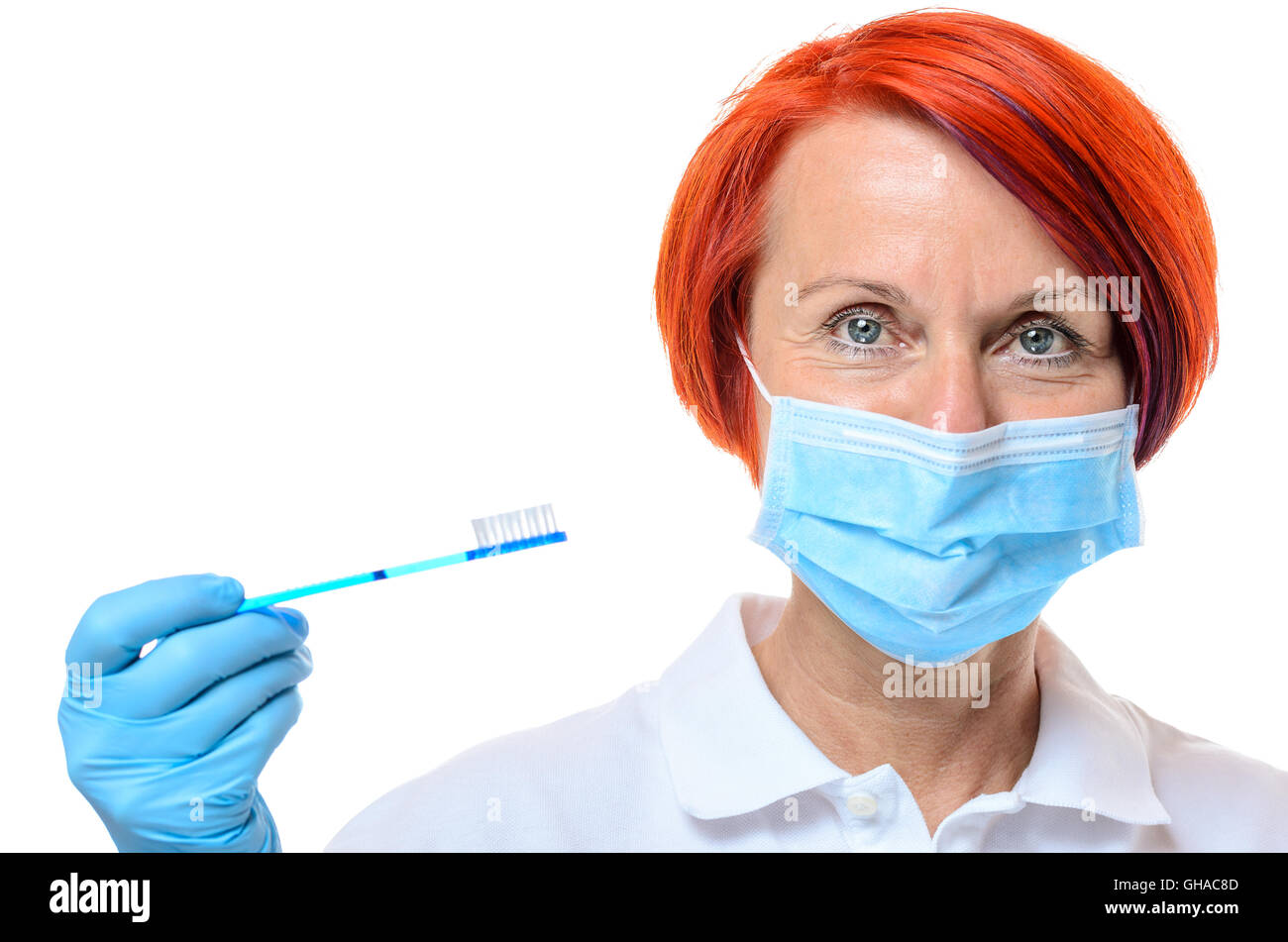 Single dental hygienist in red hair with face mask and toothbrush in ...