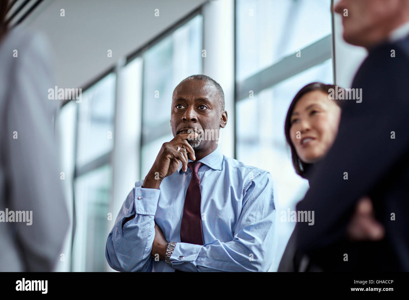 Attentive serious businessman listening to colleagues Stock Photo - Alamy