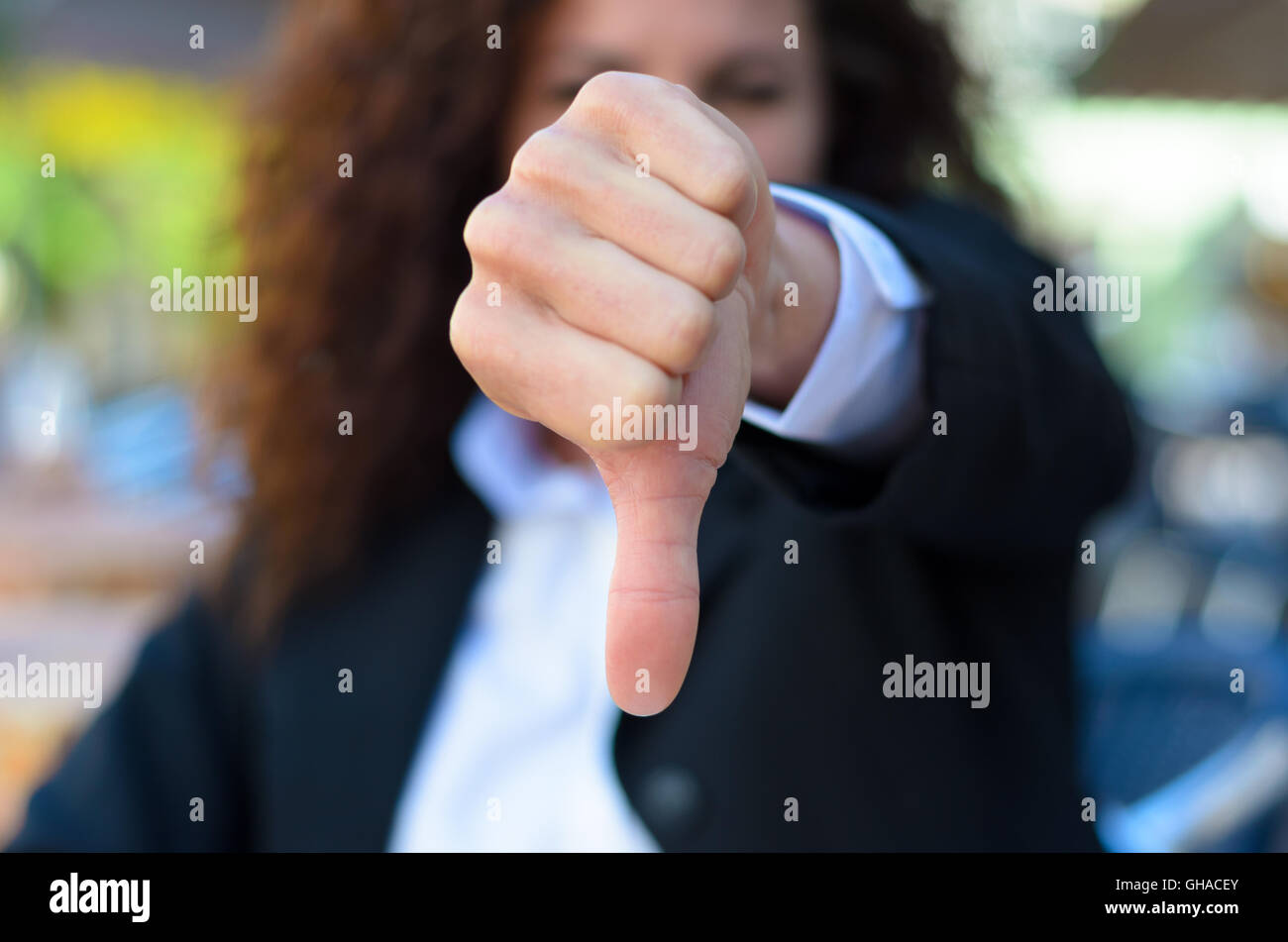 Woman making a thumbs down gesture to show disapproval, failure or ...