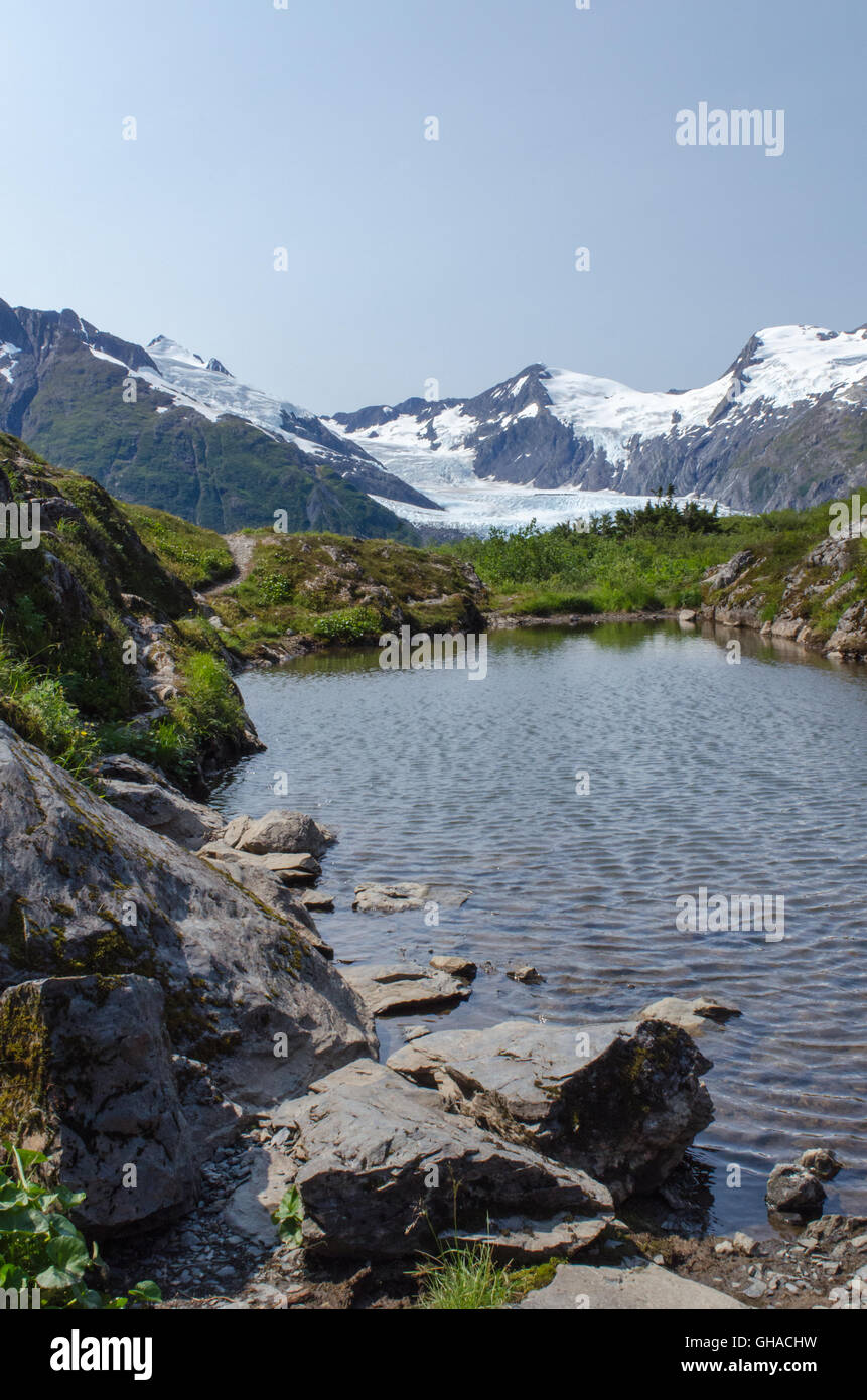 Wind whips up small ripples in a small pond on the saddle of mountain ...