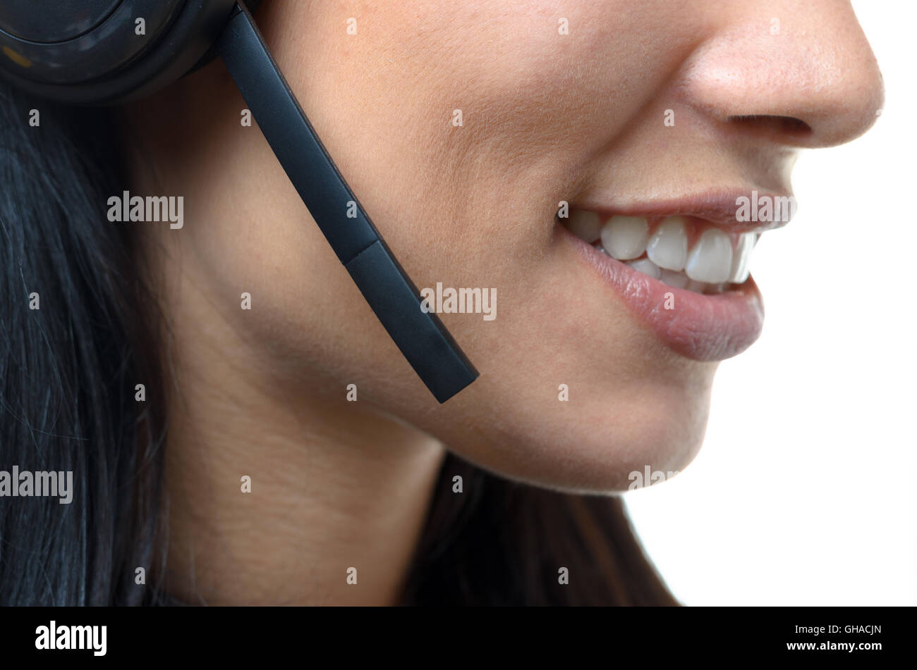 Close up view of the smiling mouth of a businesswoman using a headset ...
