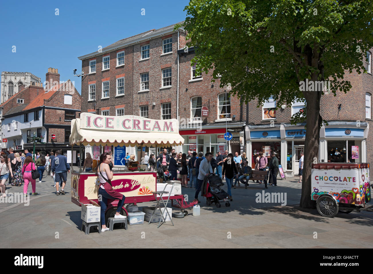 People enjoying ice cream in the summer sunshine Kings Square York City ...