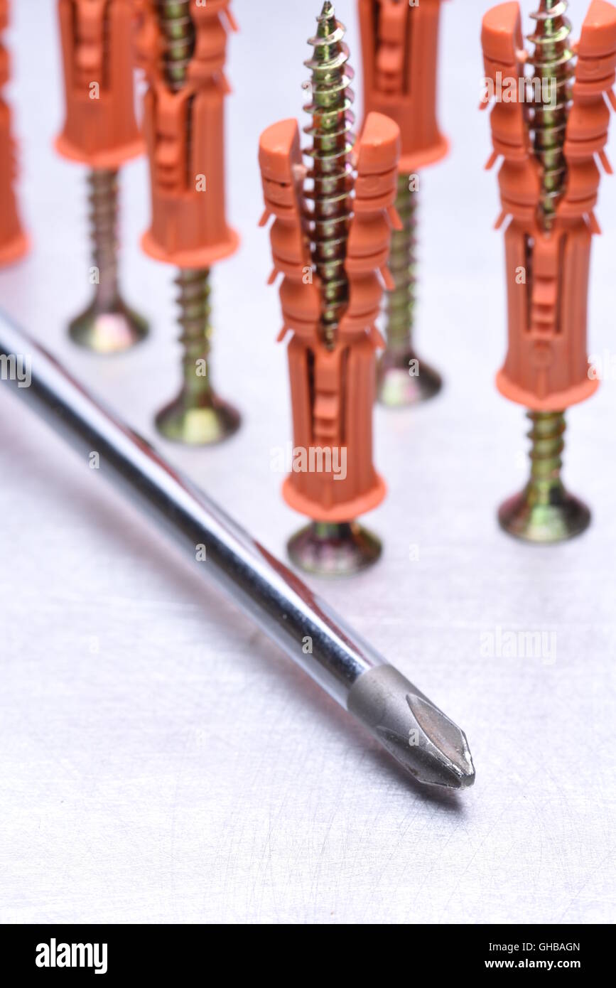 Screwdriver and dowel close up on metal background Stock Photo - Alamy