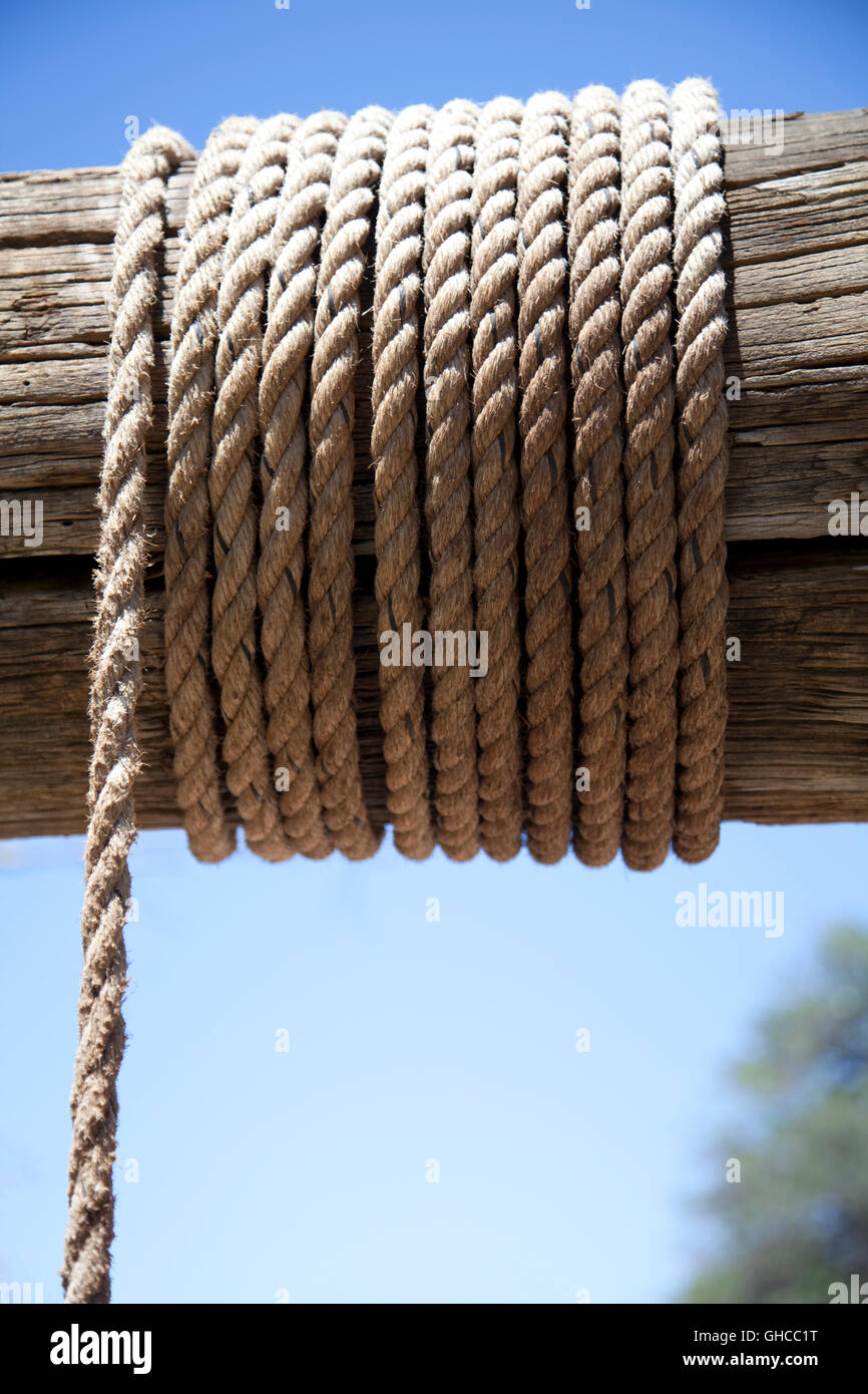 Coiled Rope Round Wooden Support Beam on Well Stock Photo - Alamy