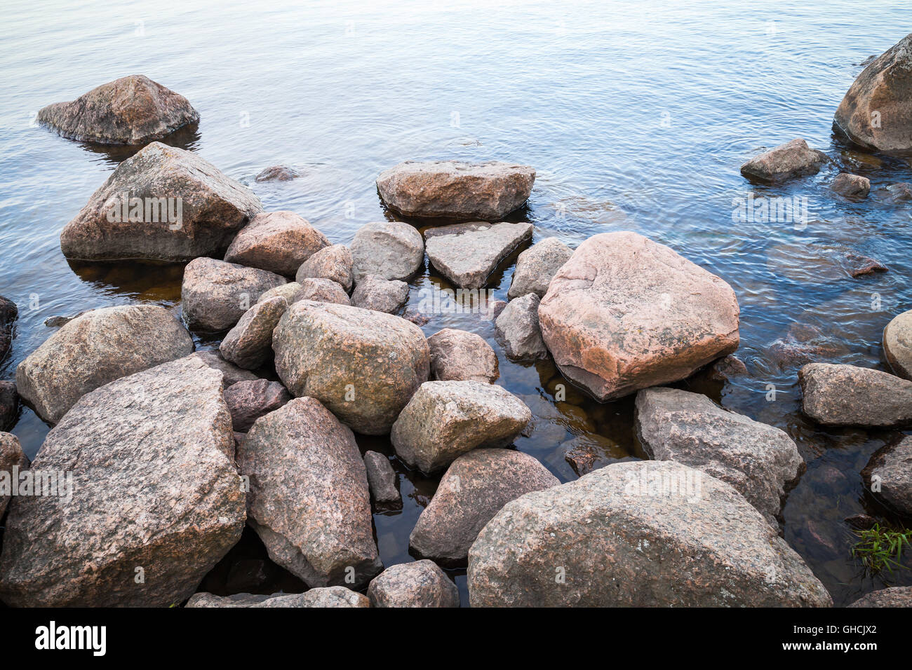 Coastal granite stones lay in still lake water Stock Photo - Alamy