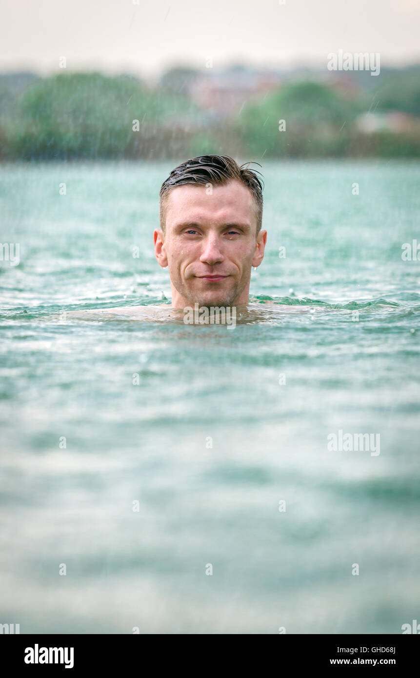 Man swimming in lake under the rain in thunderstorm Stock Photo - Alamy