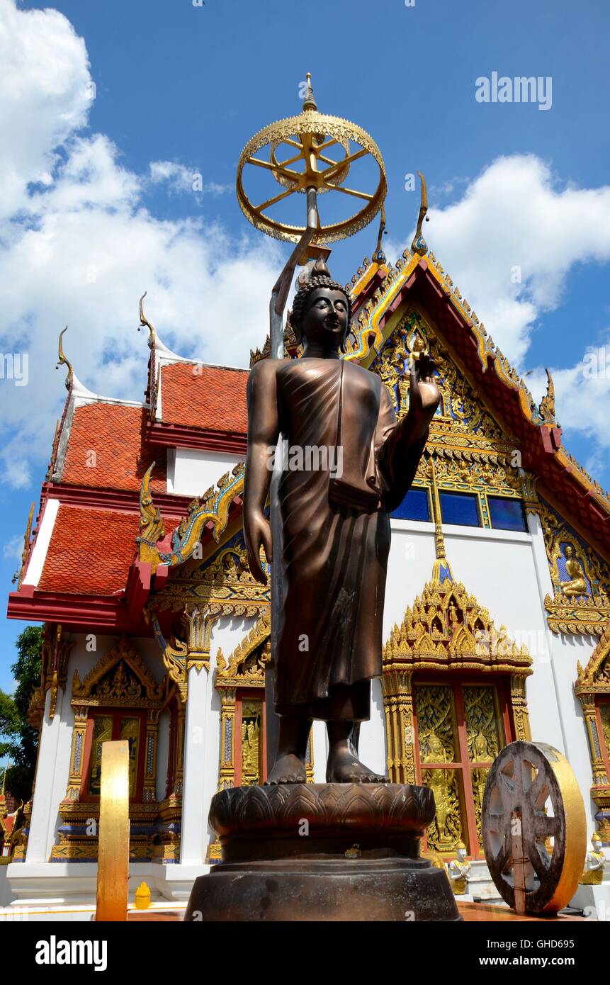 Buddha statue with sunshade and mandala wheel of life outside temple ...