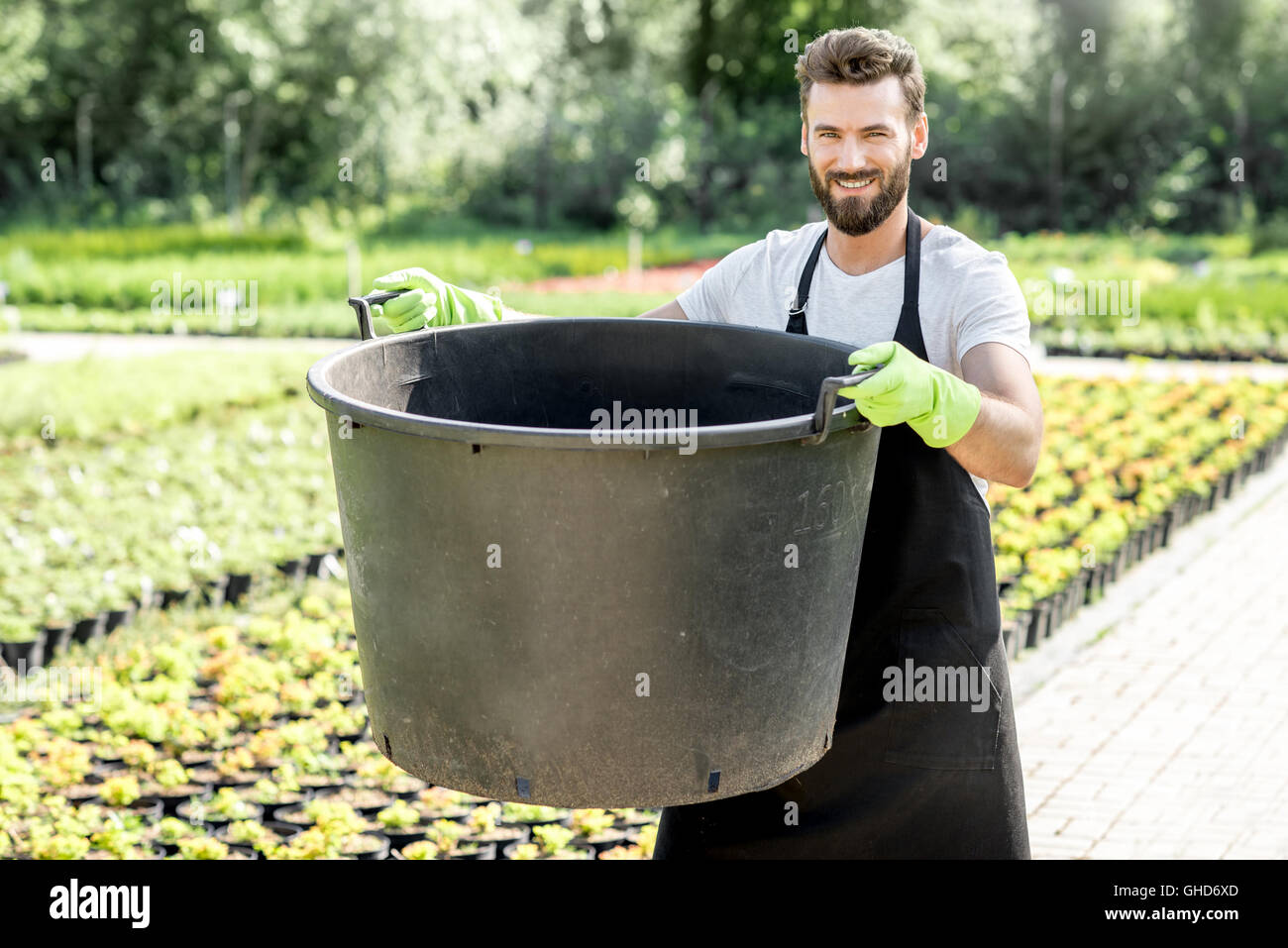 Handsome gardener with huge bucket Stock Photo - Alamy
