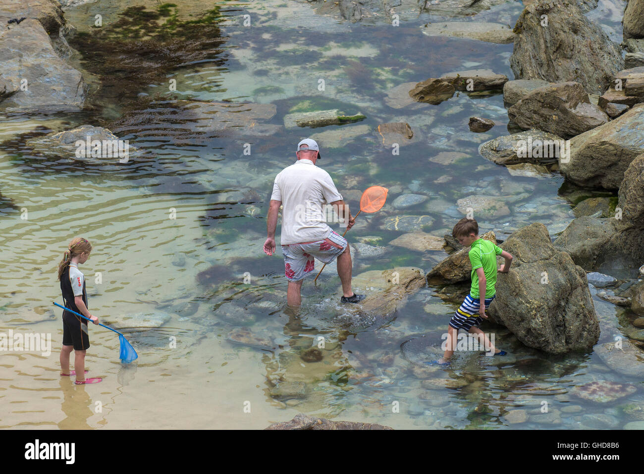 Holidaymakers exploring rock pools on Porth Beach in Newquay, Cornwall ...