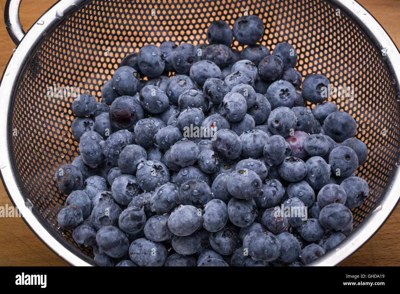 Fresh blueberries in stainless steel colander on a wood surface Stock ...