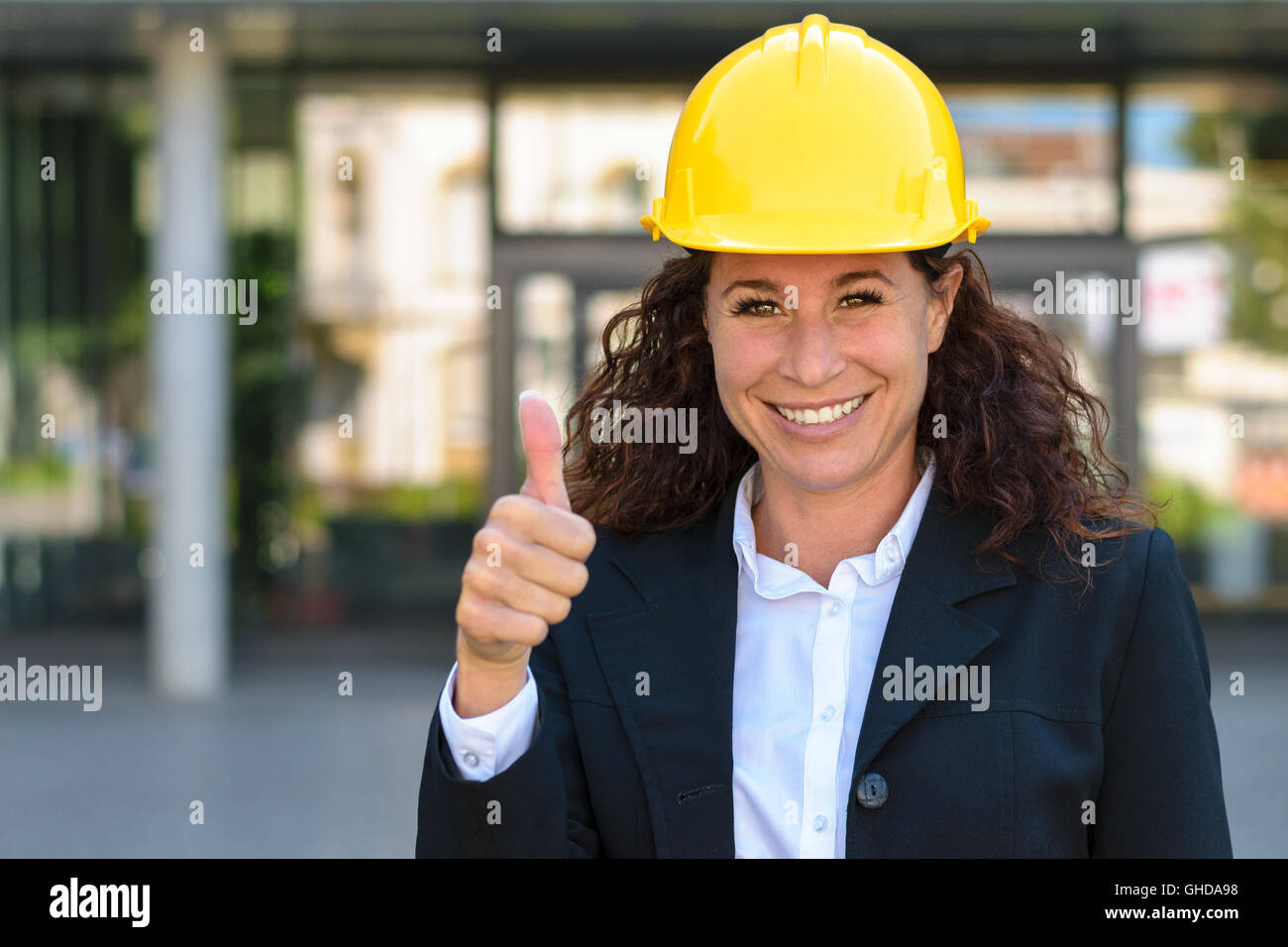 Happy successful young female architect or structural engineer wearing ...