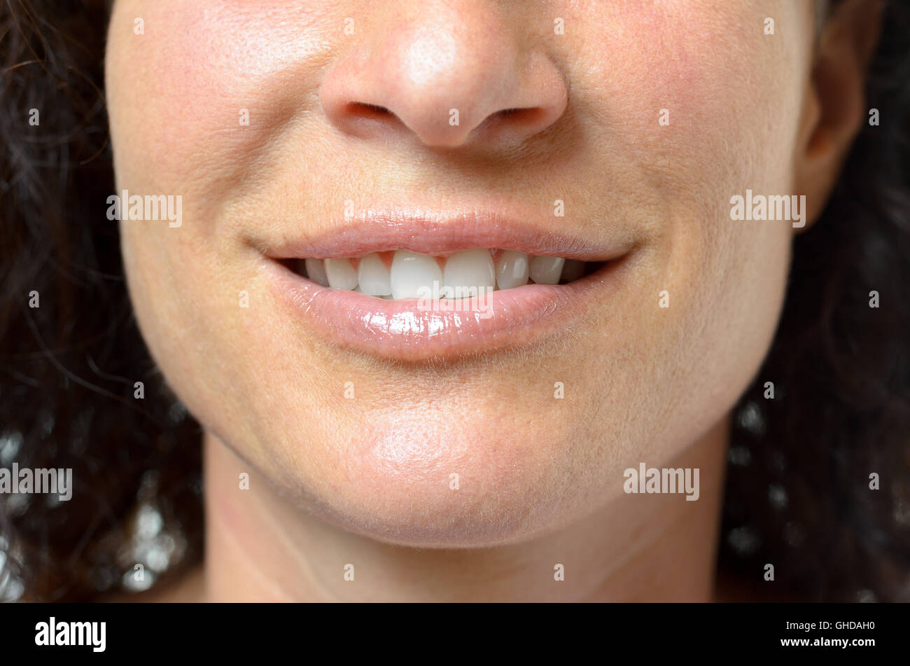 Young woman with a lovely sensual smile and slightly parted lips ...