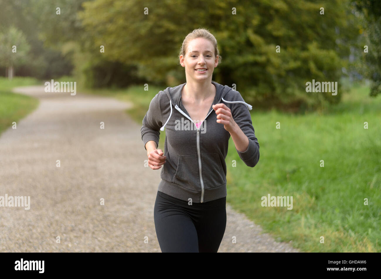 Woman running on path smiling hi-res stock photography and images - Alamy