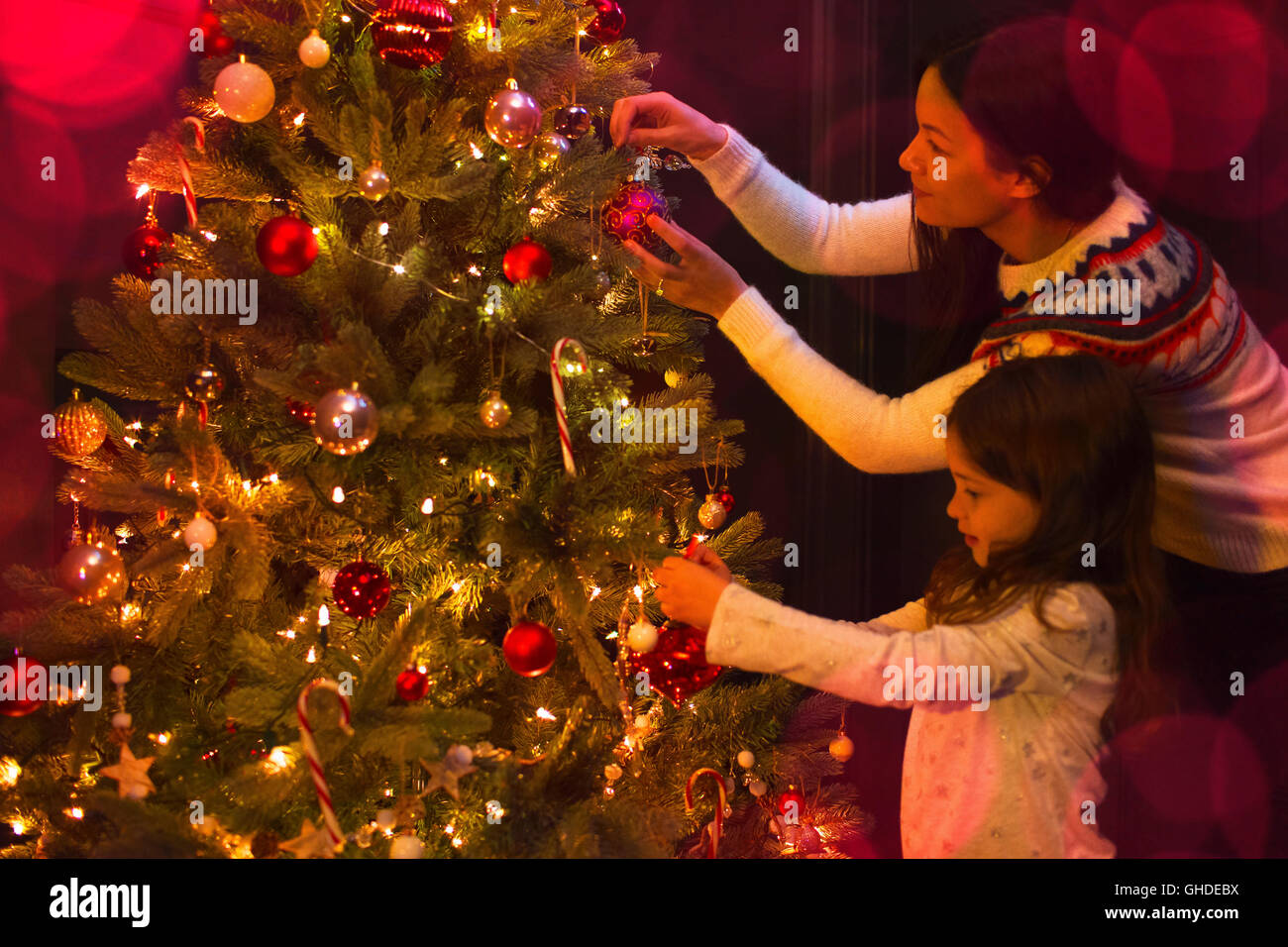 Mother and daughter decorating Christmas tree Stock Photo - Alamy